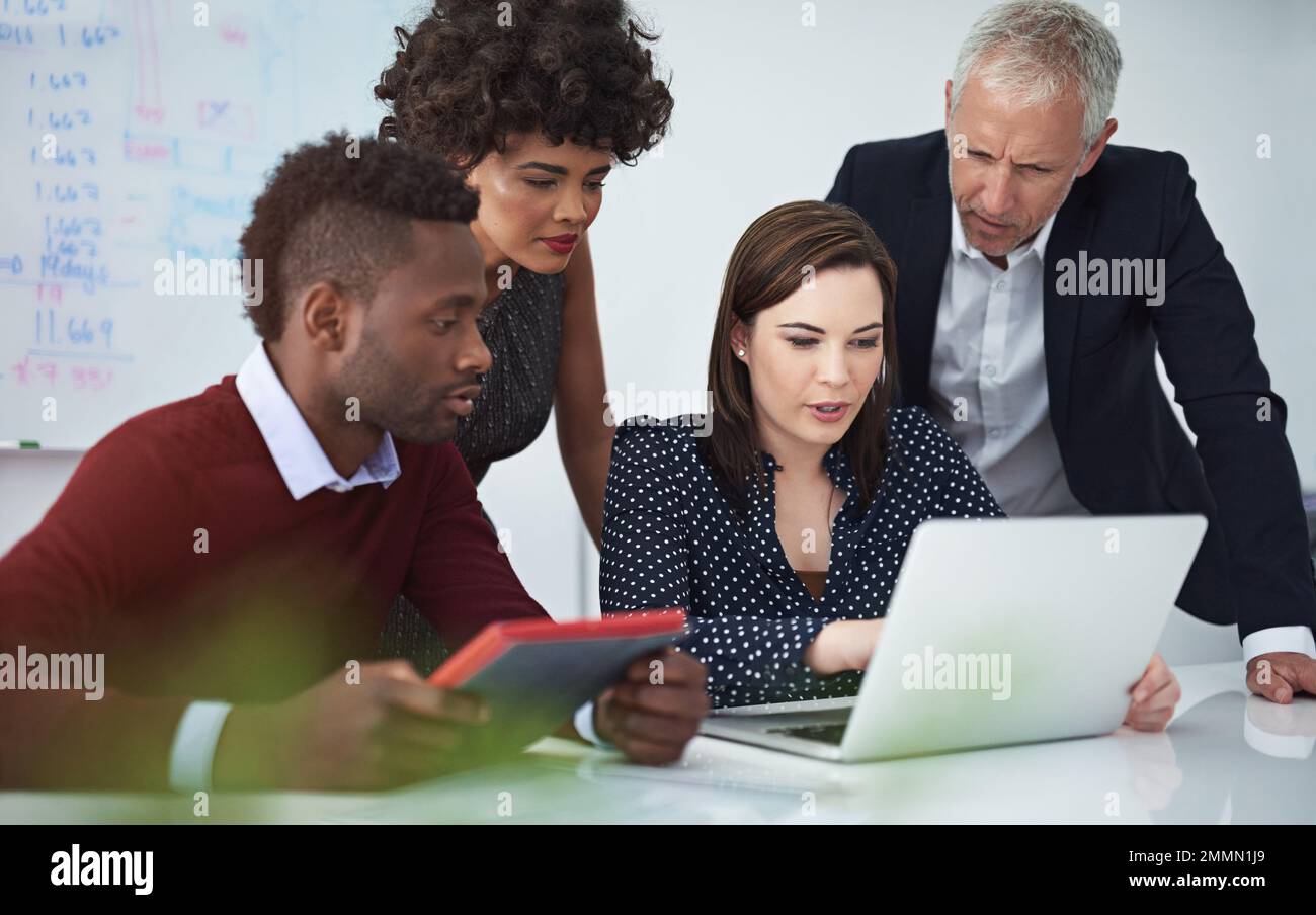 Giving them a quick demonstration. a group of businesspeople discussing ...