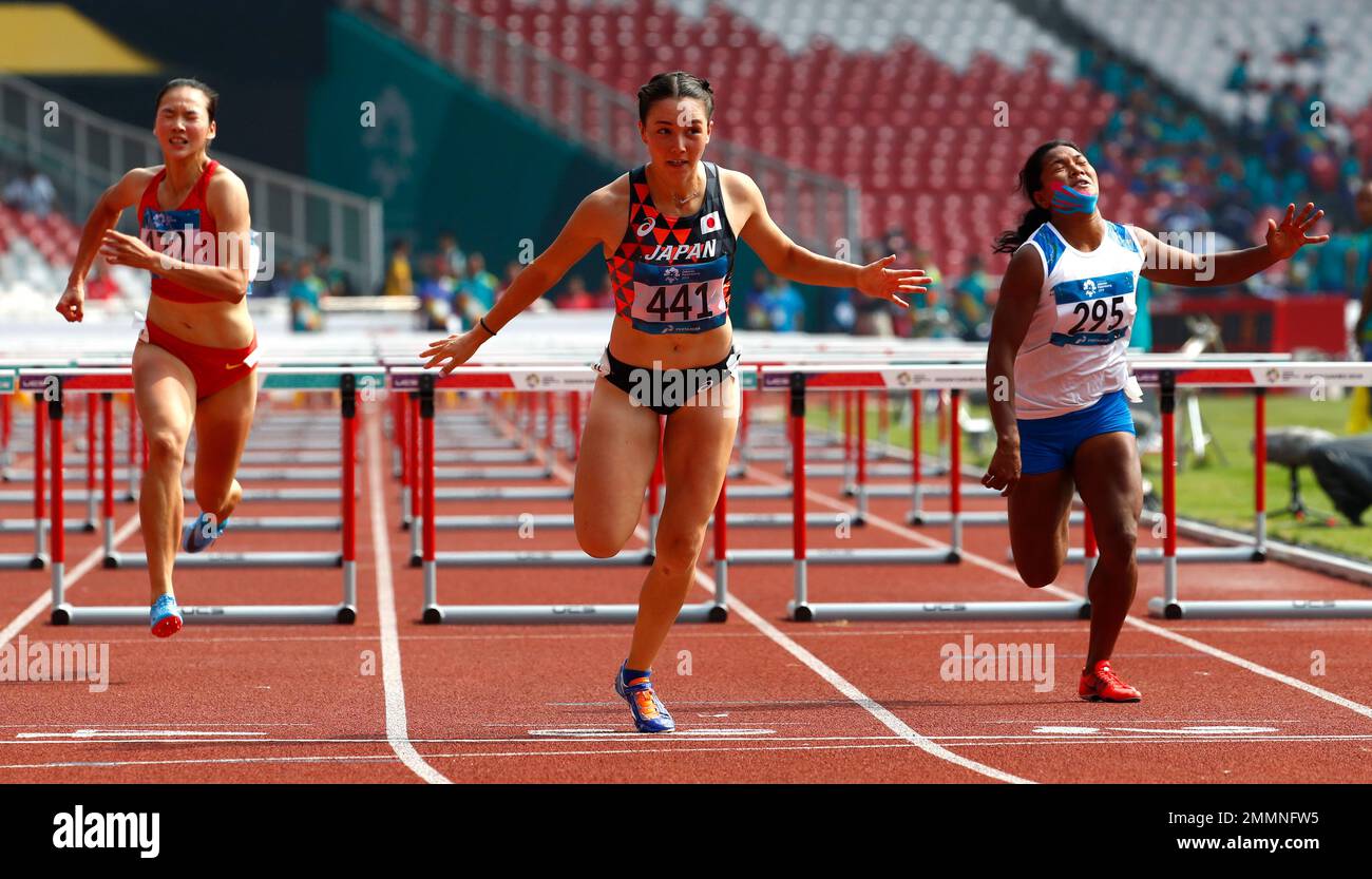 Japan's Meg Hemphill, centre, crosses the finish line ahead of India's ...