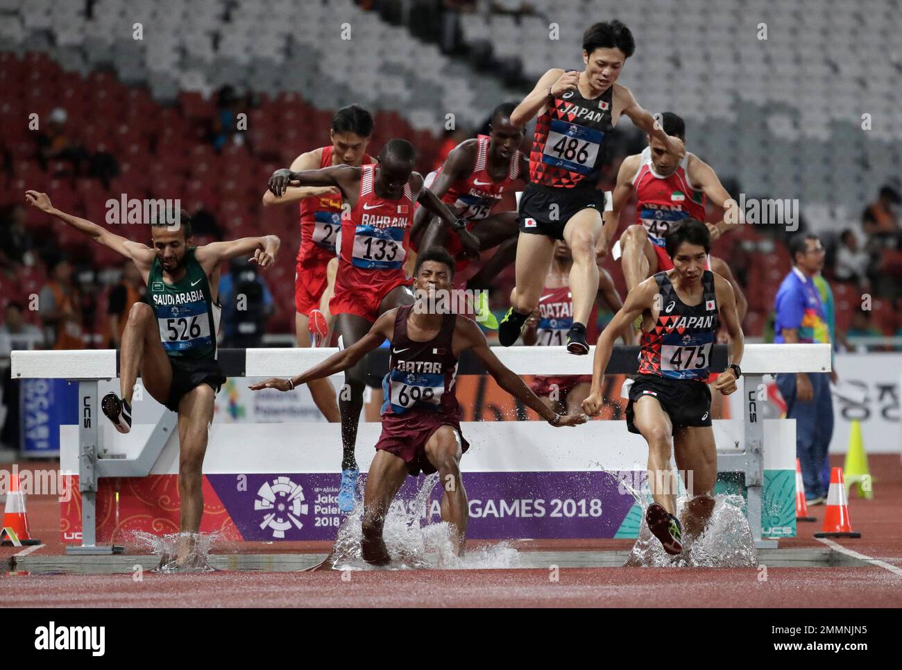 Runners in the men's 3000m steeplechase make a jump during the ...