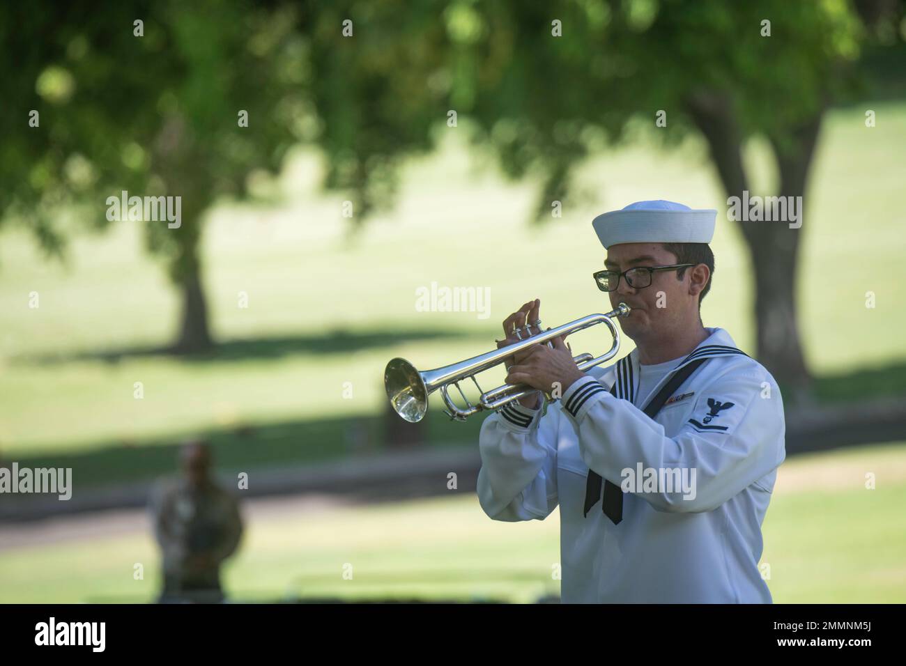 A Sailor plays taps during an interment ceremony held at the National ...