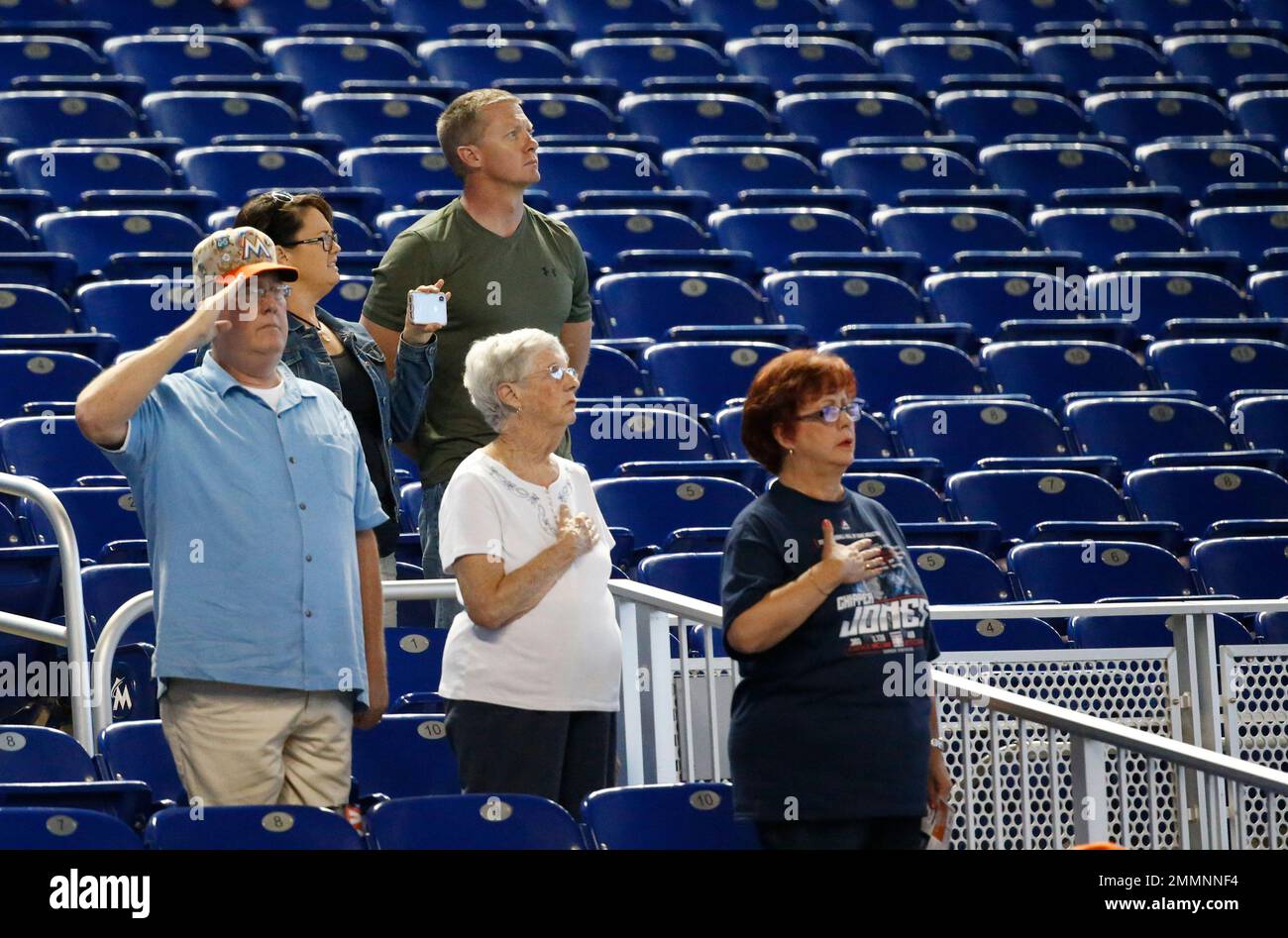 Baseball fans stand for the singing of the National Anthem before the ...