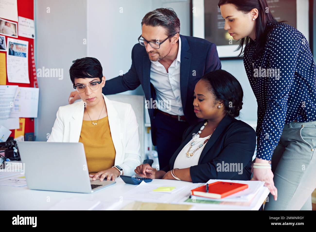 Working together to achieve success. four business colleagues working ...