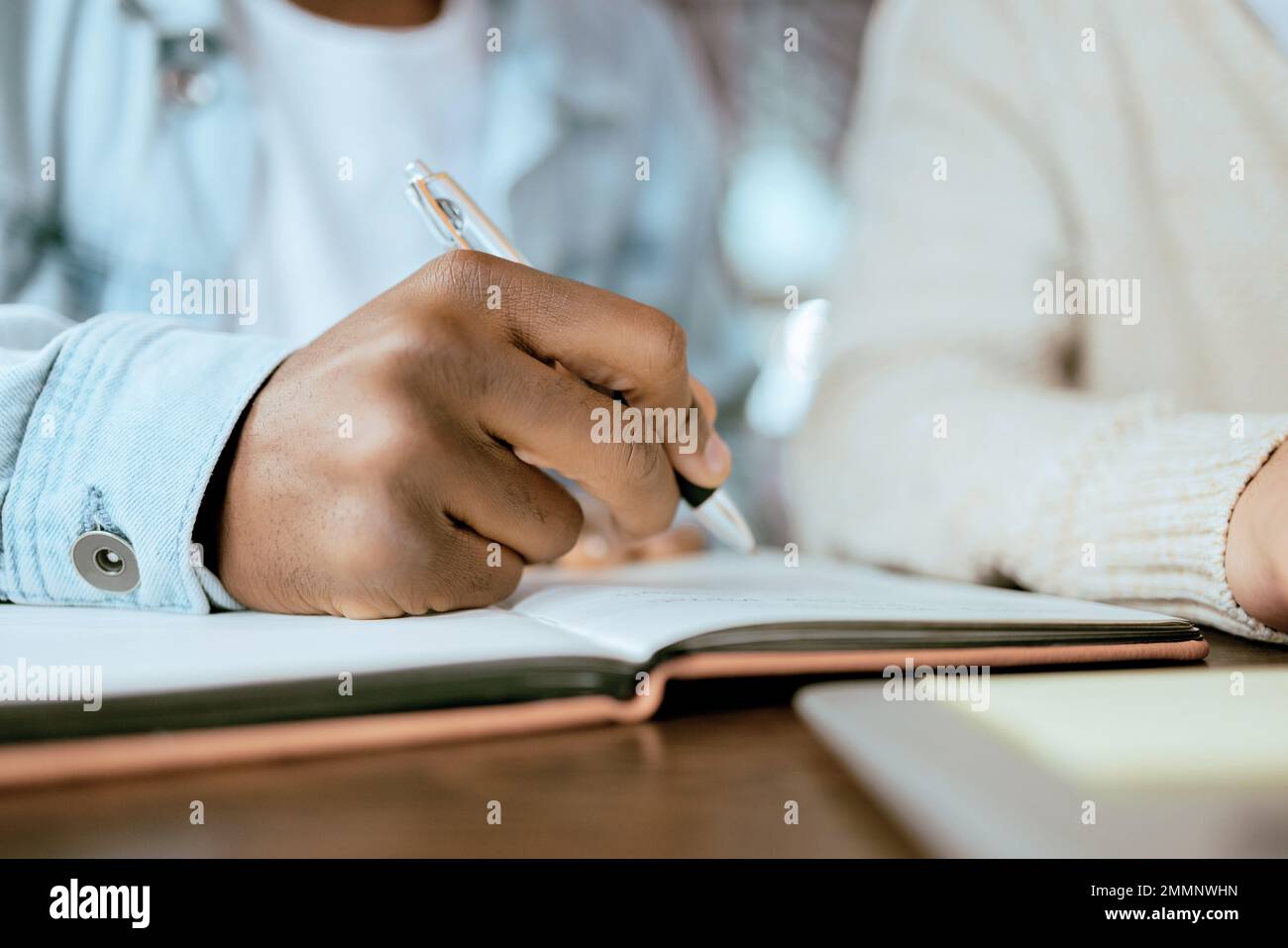 Closeup, black man hand and writing in notebook at desk for studying ...