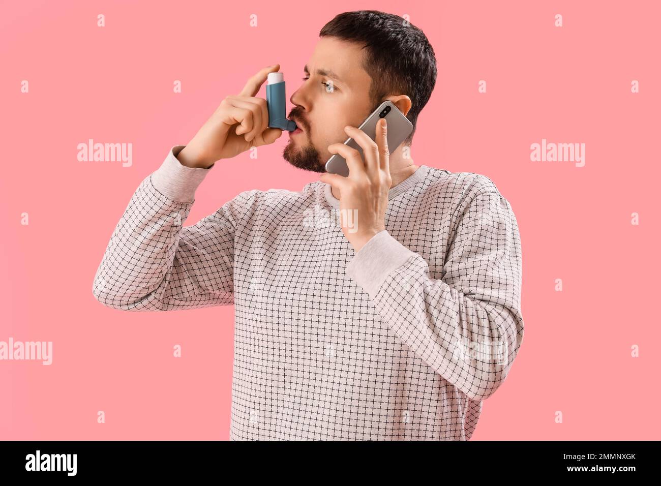 Sick man with inhaler talking by phone on pink background Stock Photo ...