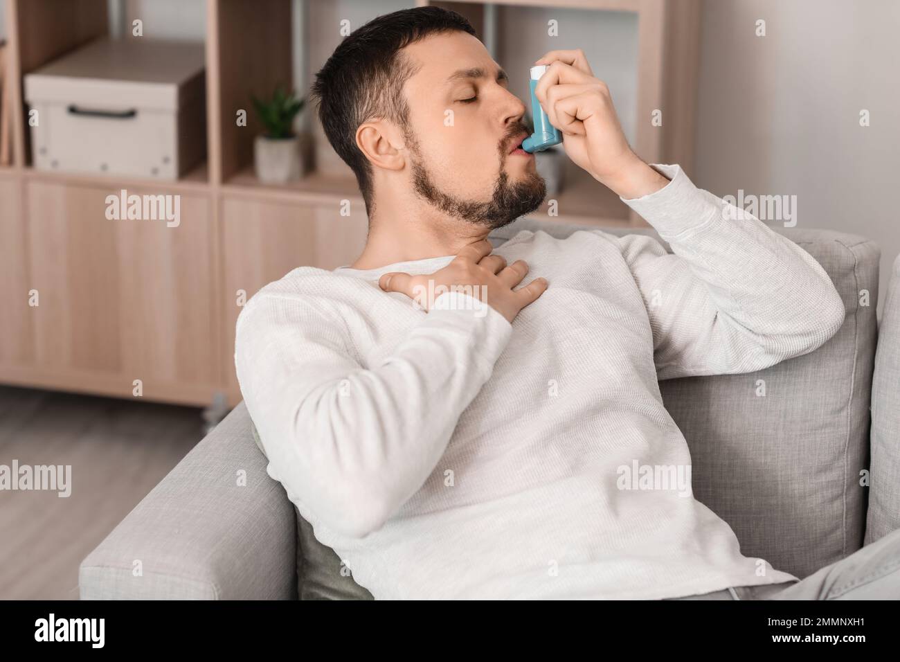 Sick man using inhaler at home Stock Photo - Alamy