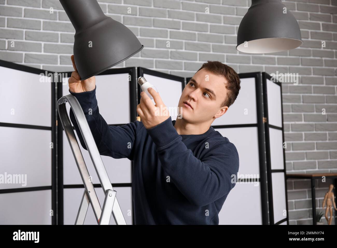 Man changing light bulb on ladder hi-res stock photography and images ...