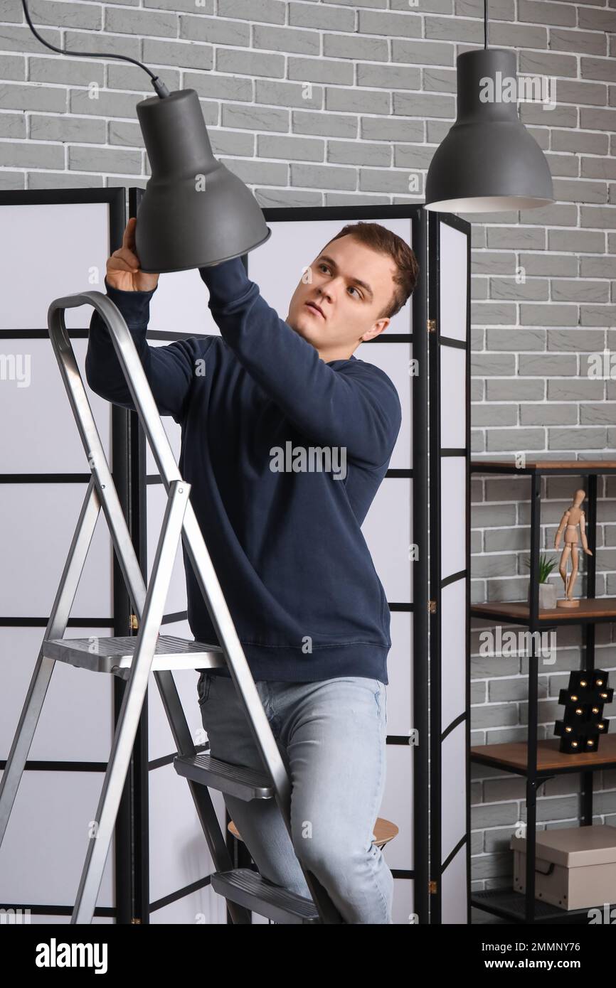 Man changing light bulb on ladder hi-res stock photography and images ...
