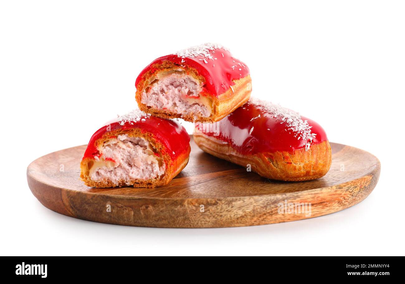 Wooden board with halves of delicious eclairs isolated on white ...