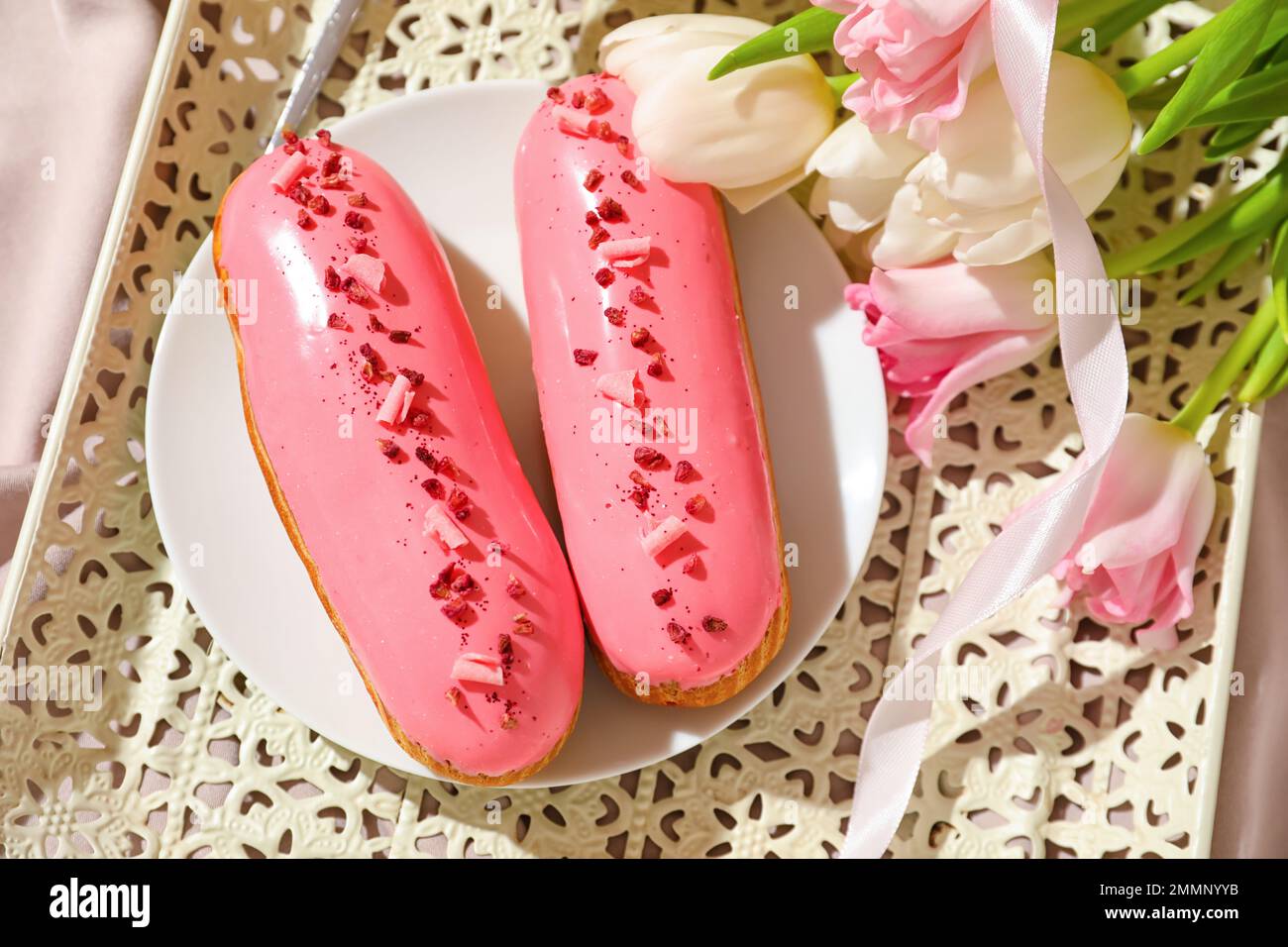 Tray with delicious eclairs and flowers on light background Stock Photo ...