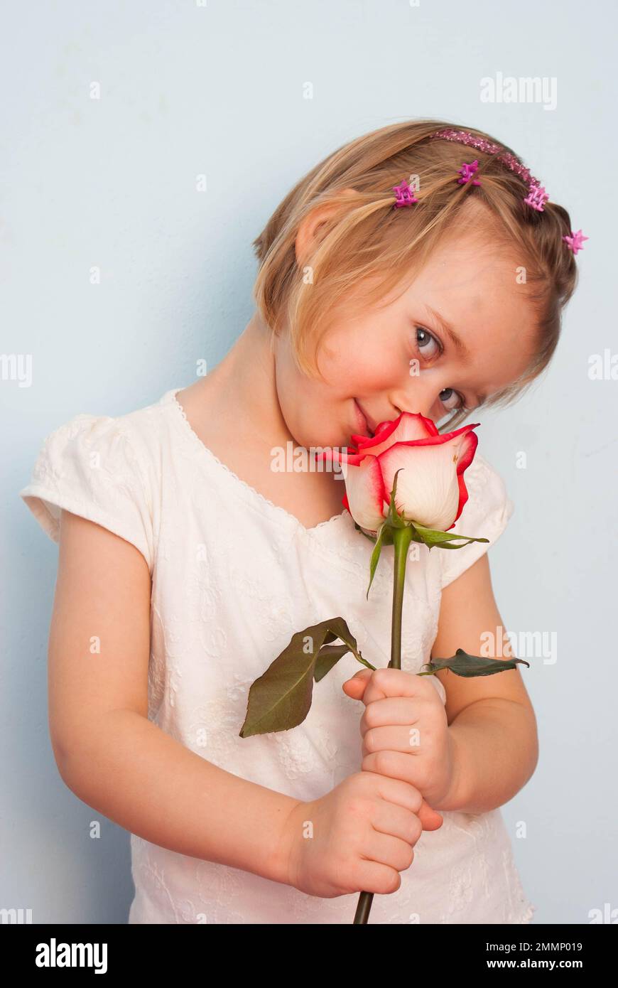 Happy little girl with her first rose Stock Photo - Alamy