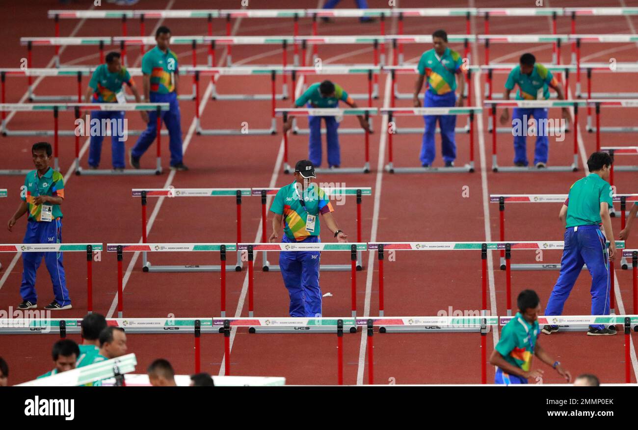 Track marshals remove hurdles from the track during the athletics ...