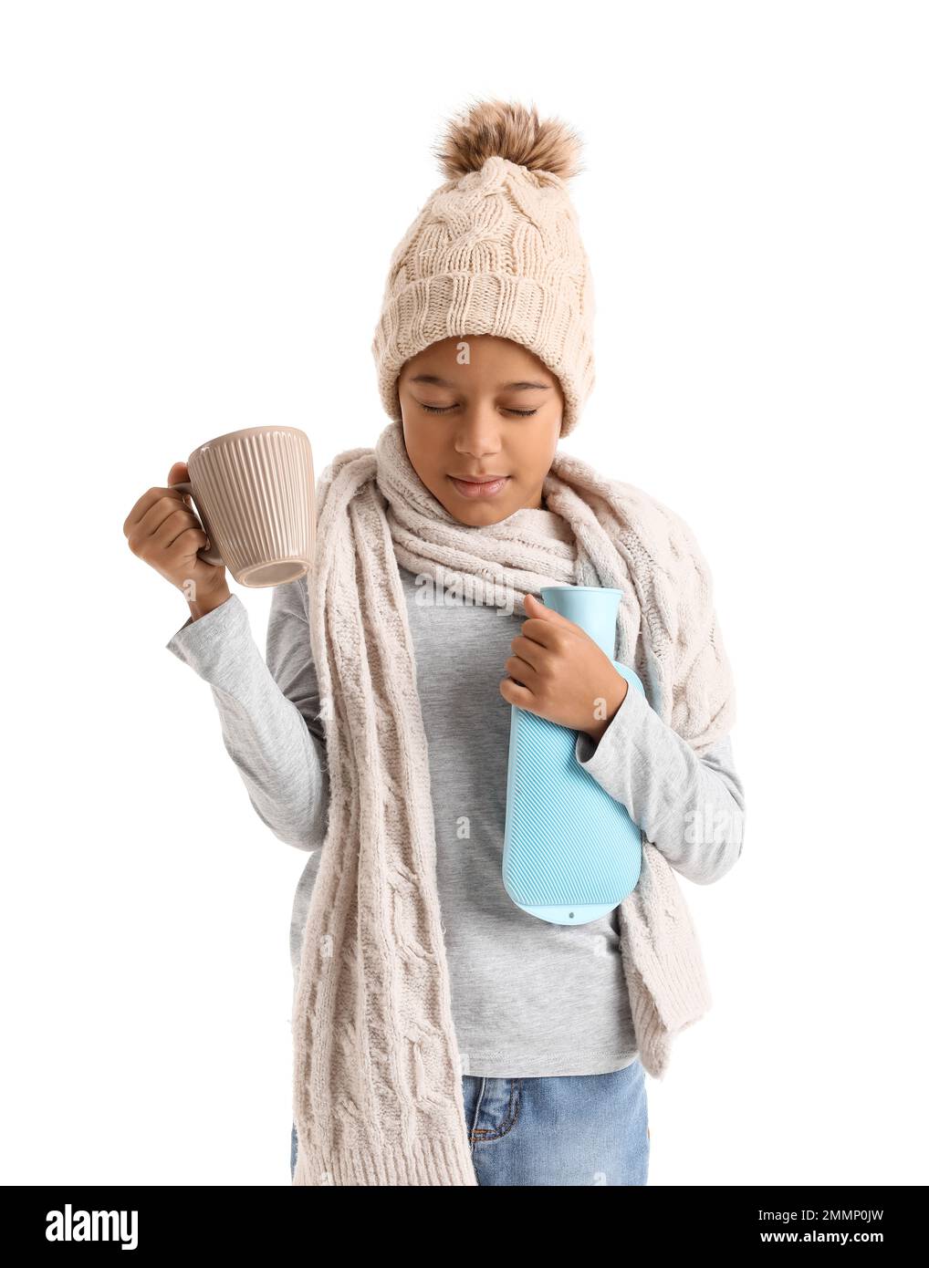 Ill African-American boy with hot water bottle and cup of tea on white ...