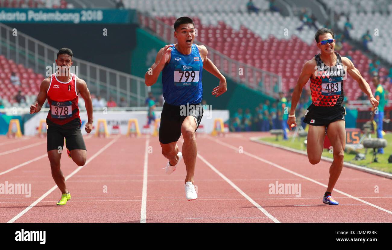 Thailand's Suttisak Singkhuon, centre, crosses the finish line to win ...