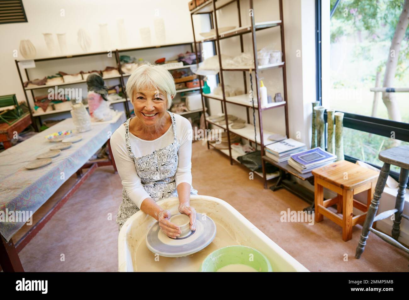 Learning the art of pottery. a senior woman making a ceramic pot in a ...