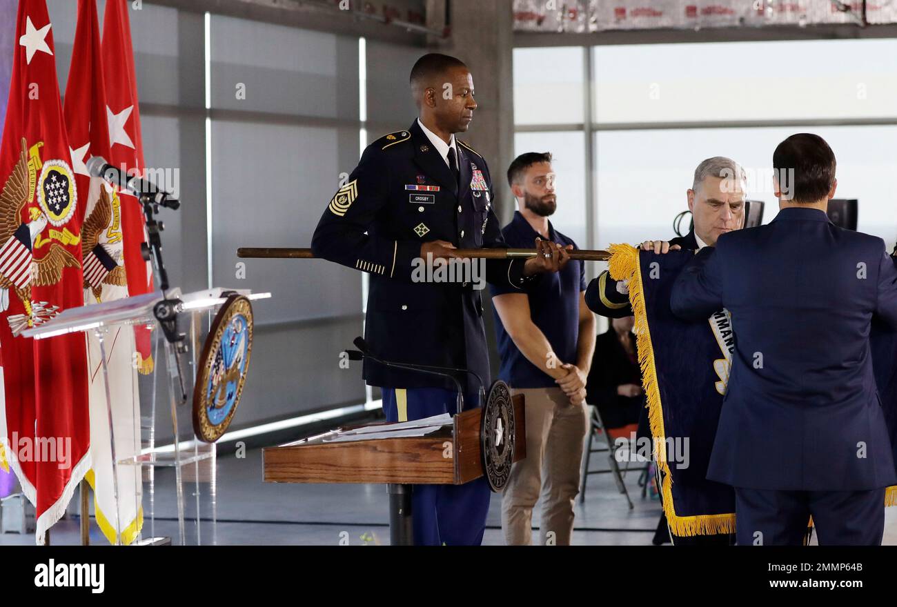 Command Sgt. Maj. Michael Crosby, left, unfurls the new flag during an ...