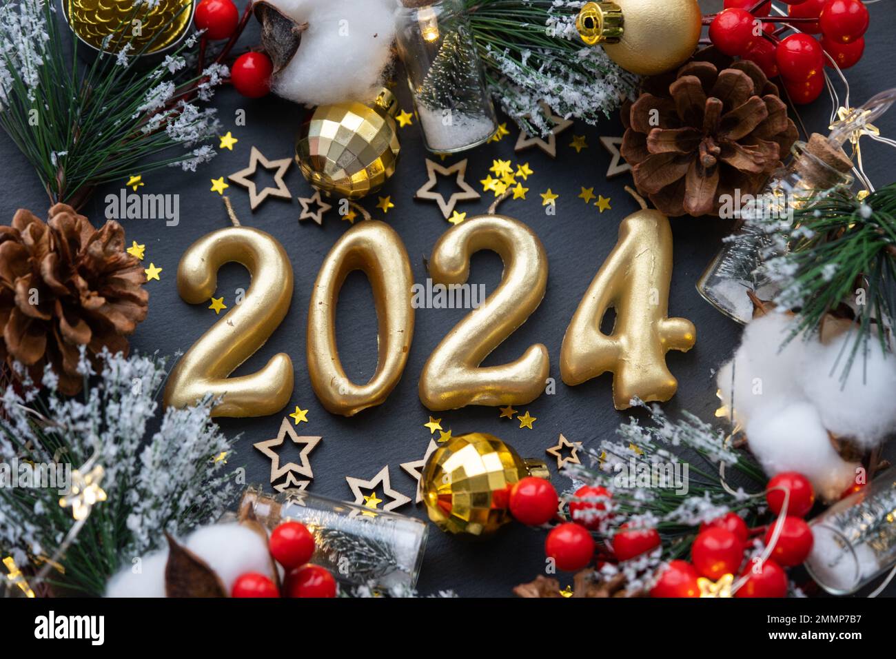 The golden figures 2024 made of candles on a black stone slate ...