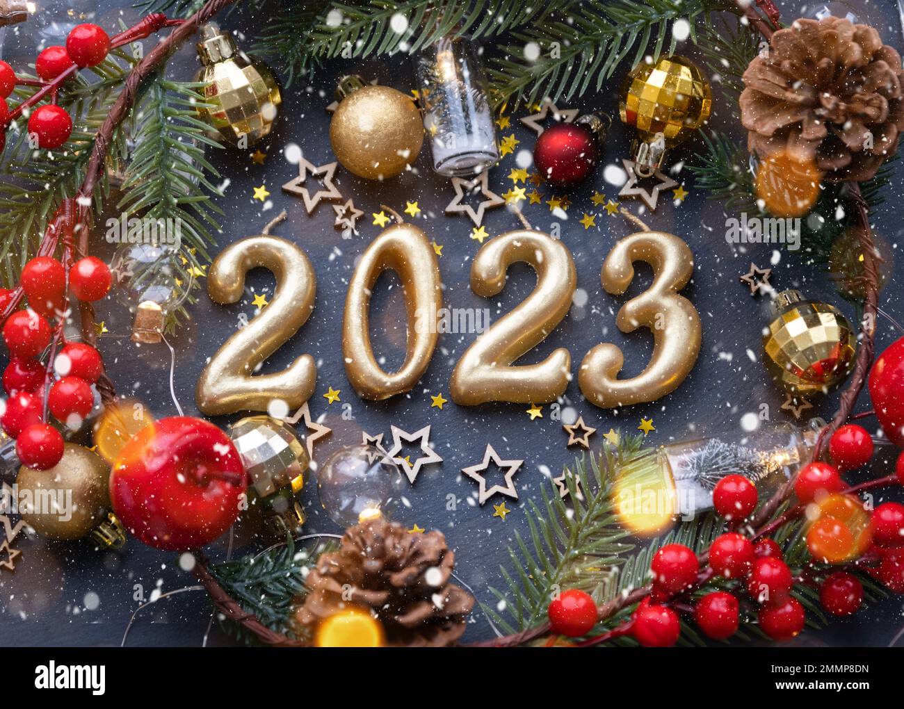 The golden figures 2023 made of candles on a black stone slate ...