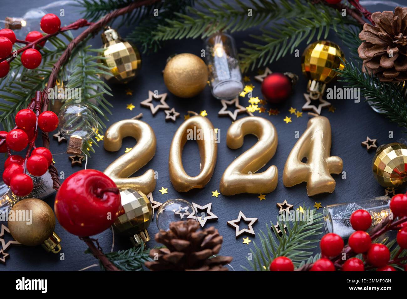 The golden figures 2024 made of candles on a black stone slate ...