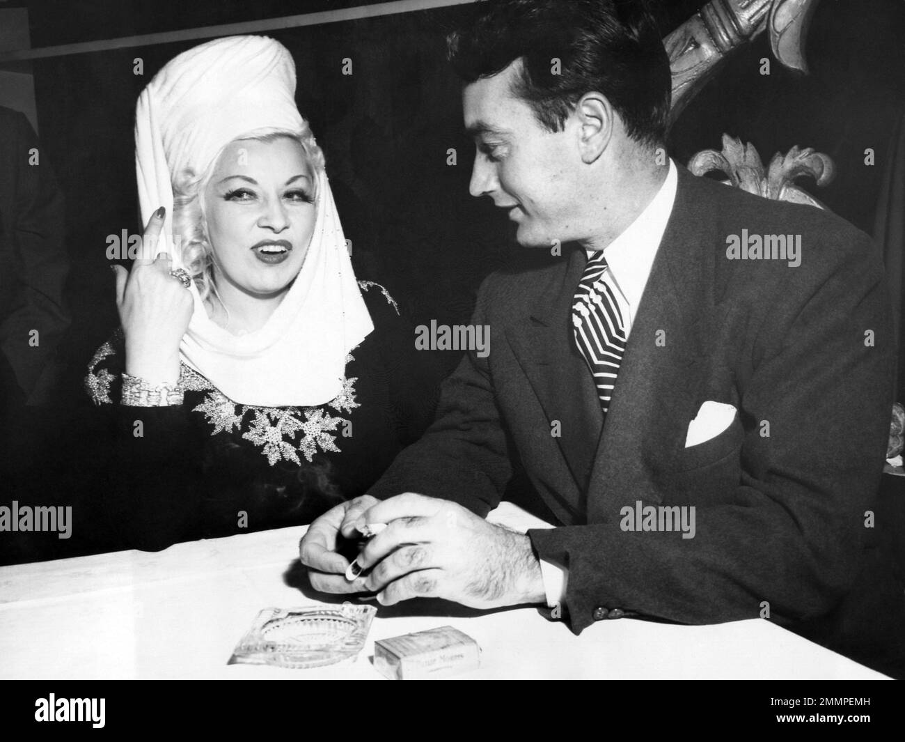 Mae West, stage and movie actress, wears an attention-getting draped ...