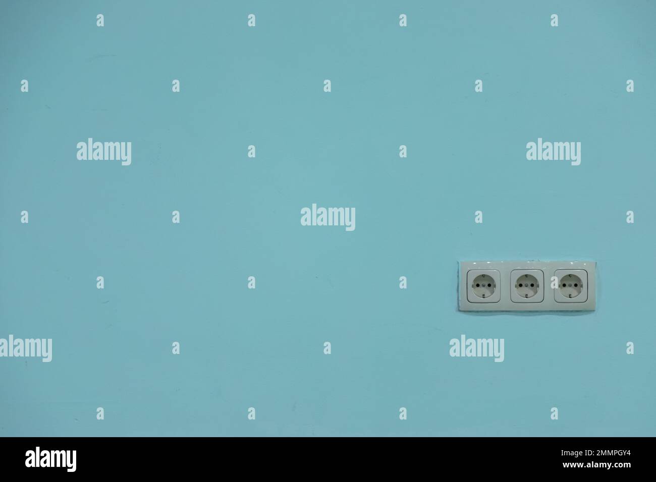 white electrical outlet on a blue wall, background Stock Photo - Alamy