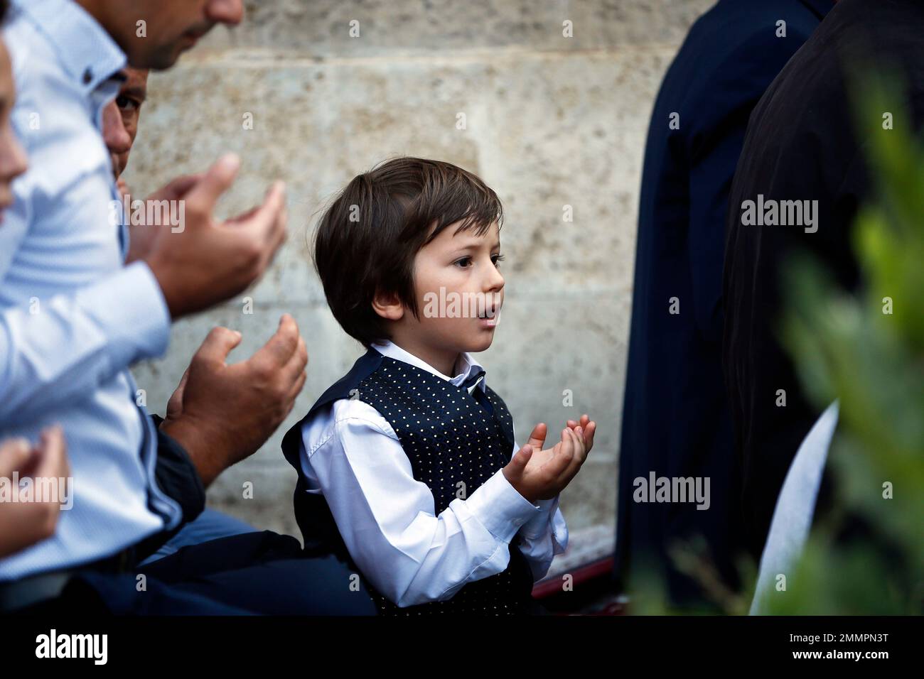 A boy offers his prayers marking the first day of Eid al-Adha outside the Sultan Mehmet Fatih ...