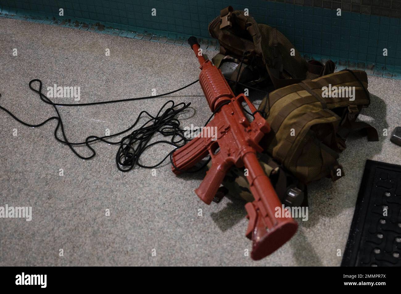 A vest and mock rifle sit beside a pool after the 20th Security Forces ...