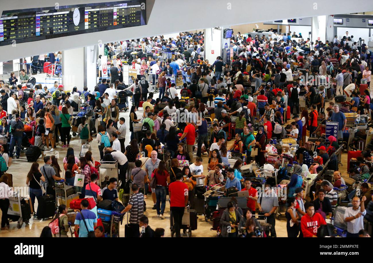 Hundreds of international passengers queue up at check-in counters ...