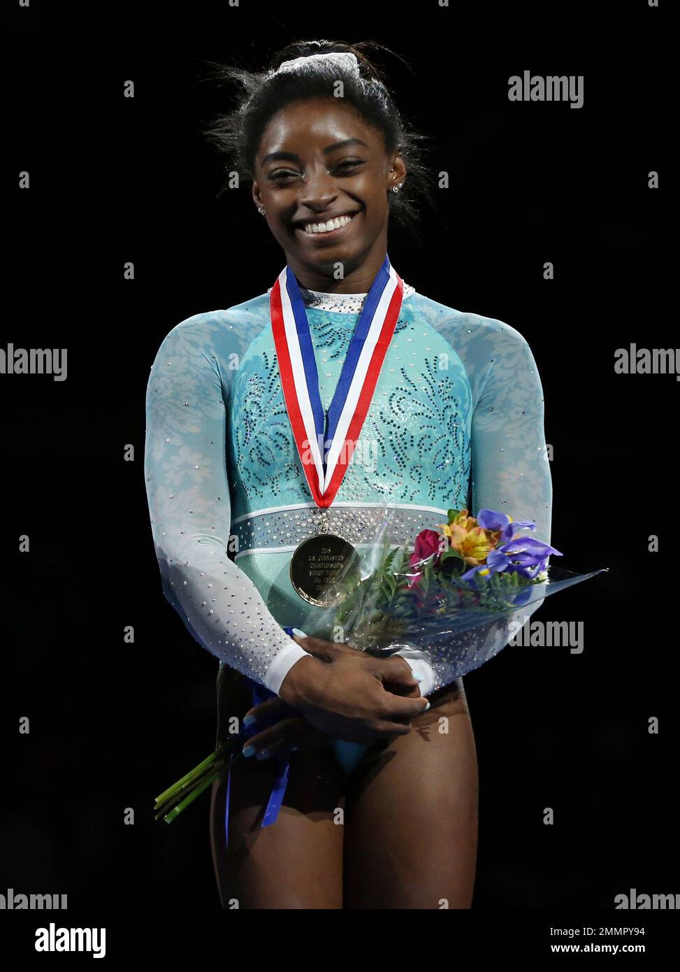 Simone Biles smiles after receiving the gold medal as top-finisher in ...