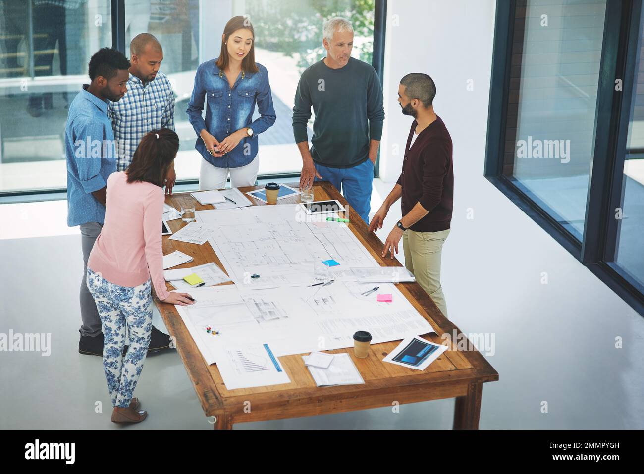 Going over the details. High angle of a group of architects looking ...