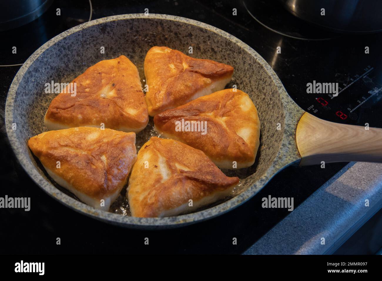 Preparation of belyashes on a frying pan. Traditional russian meat pies ...