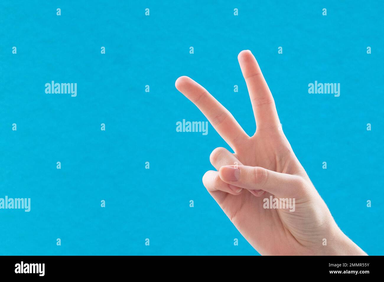 Close-up of a female hand with two fingers up a symbol of peace or ...