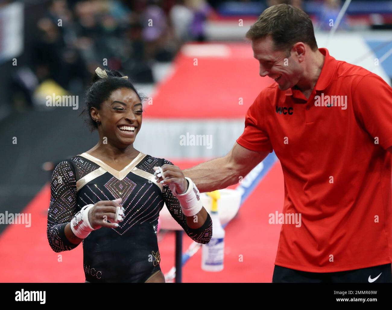 Simone Biles smiles with her coach, Laurent Landi, after competing on ...