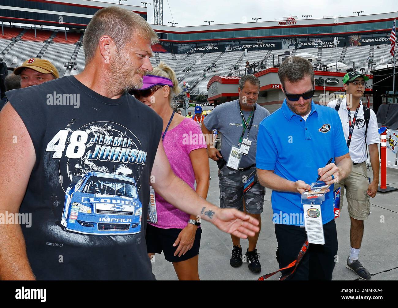 Dale Earnhardt Jr., right, signs an autograph for a fan before a NASCAR ...