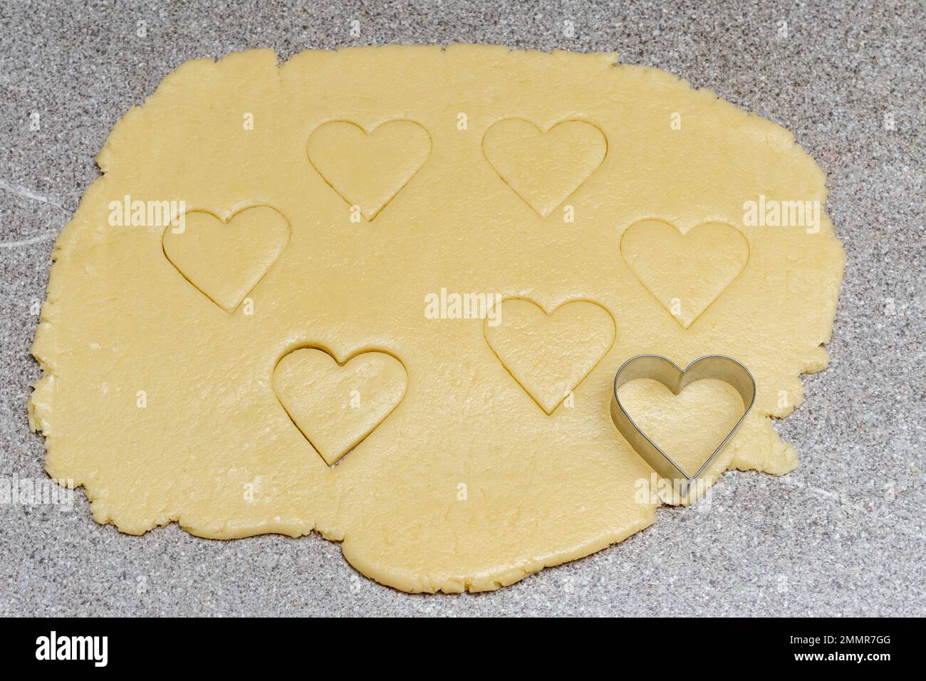 Making homemade heart shaped cookies. Dough with cooked cookie cutters ...