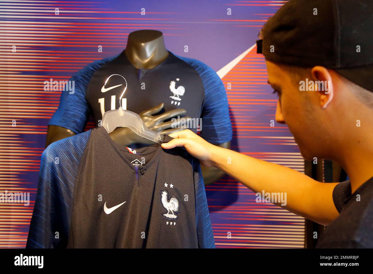 A man holds the new jersey of French national soccer team, bearing two ...