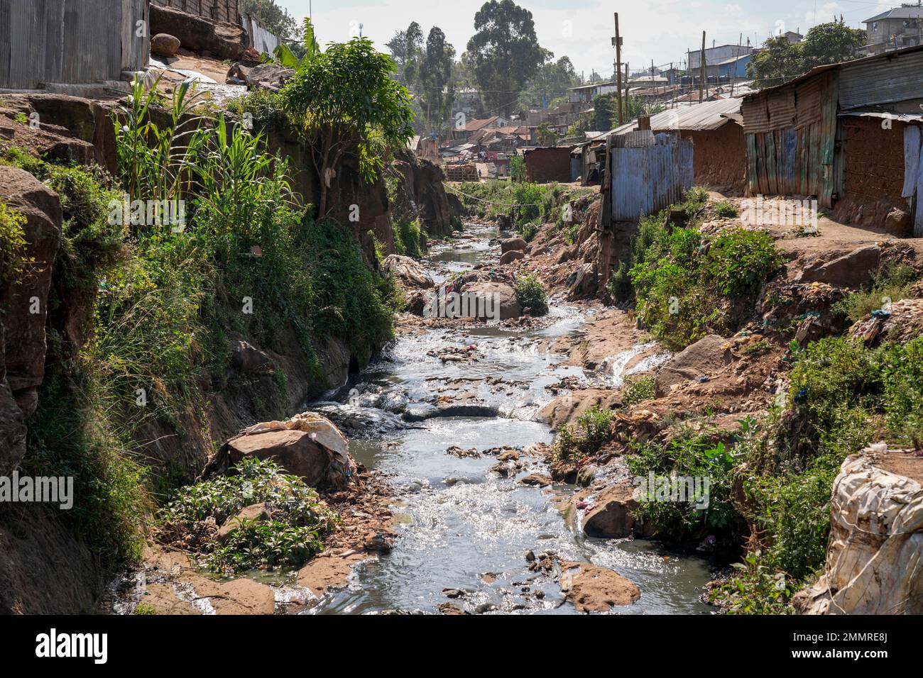 A tributary full of garbage, which feeds into the Nairobi River, flows ...