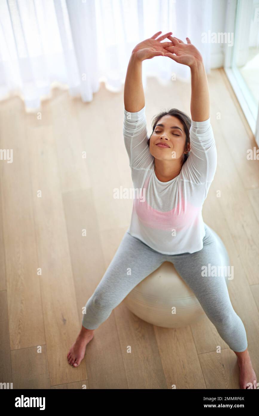 You create your own calm. a young woman working out on a fitness ball ...