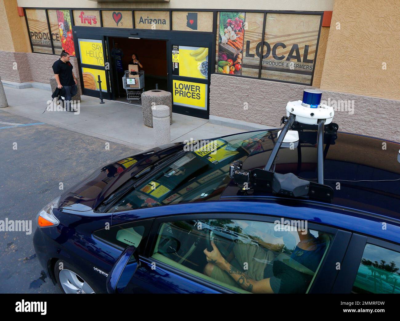 A self-driving Nuro vehicle parks outside a Fry's supermarket, which is ...