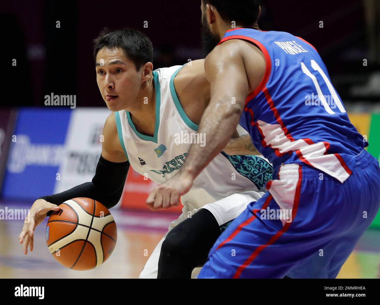 Kazakhstan's Shaim Kuanov, left, drives to the basket against ...
