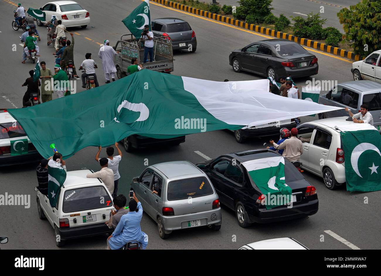 People display a large national flag during a rally to mark the country ...
