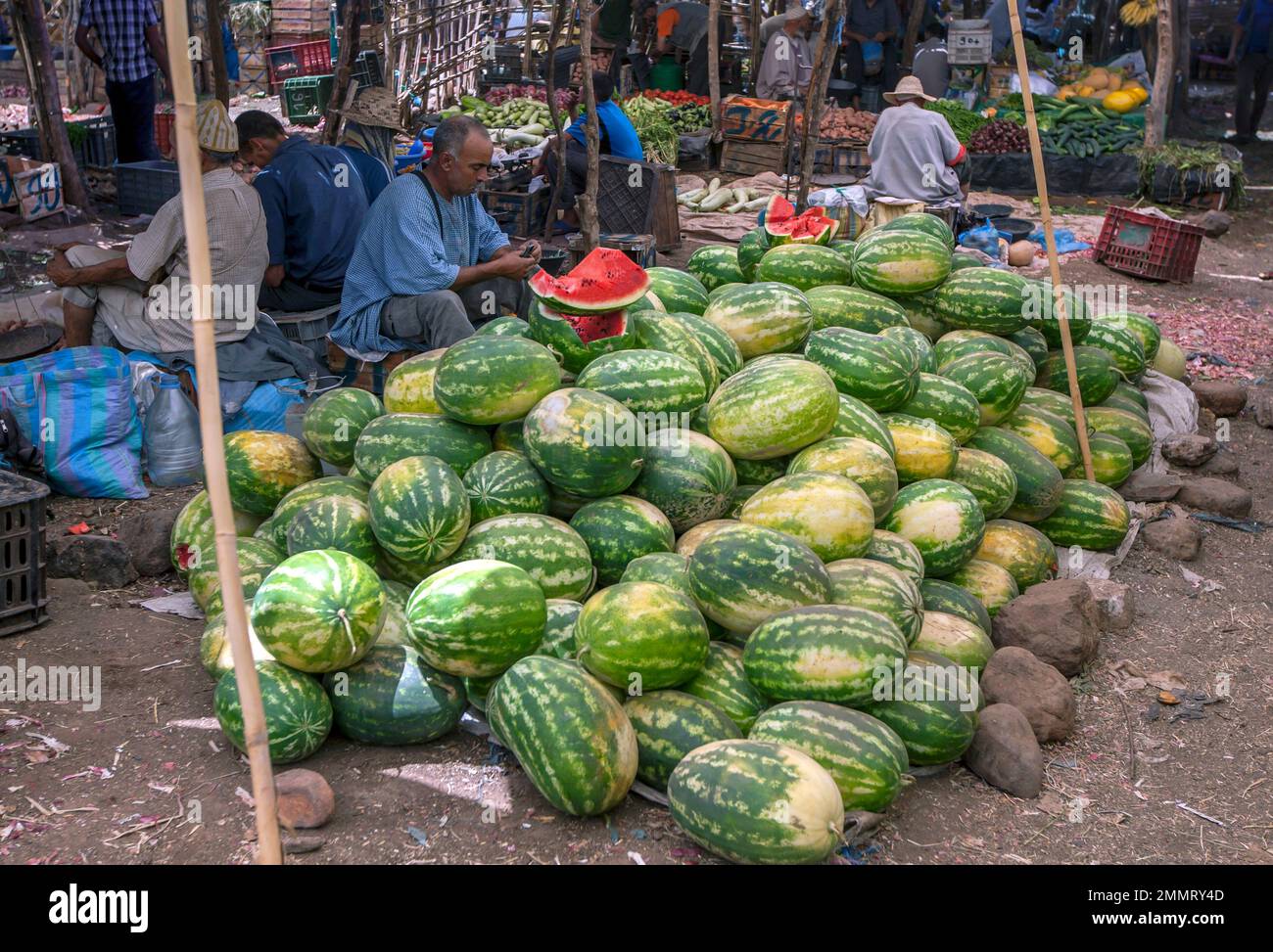 A man sits at a stall selling fresh watermelon at the Tahanoute market ...