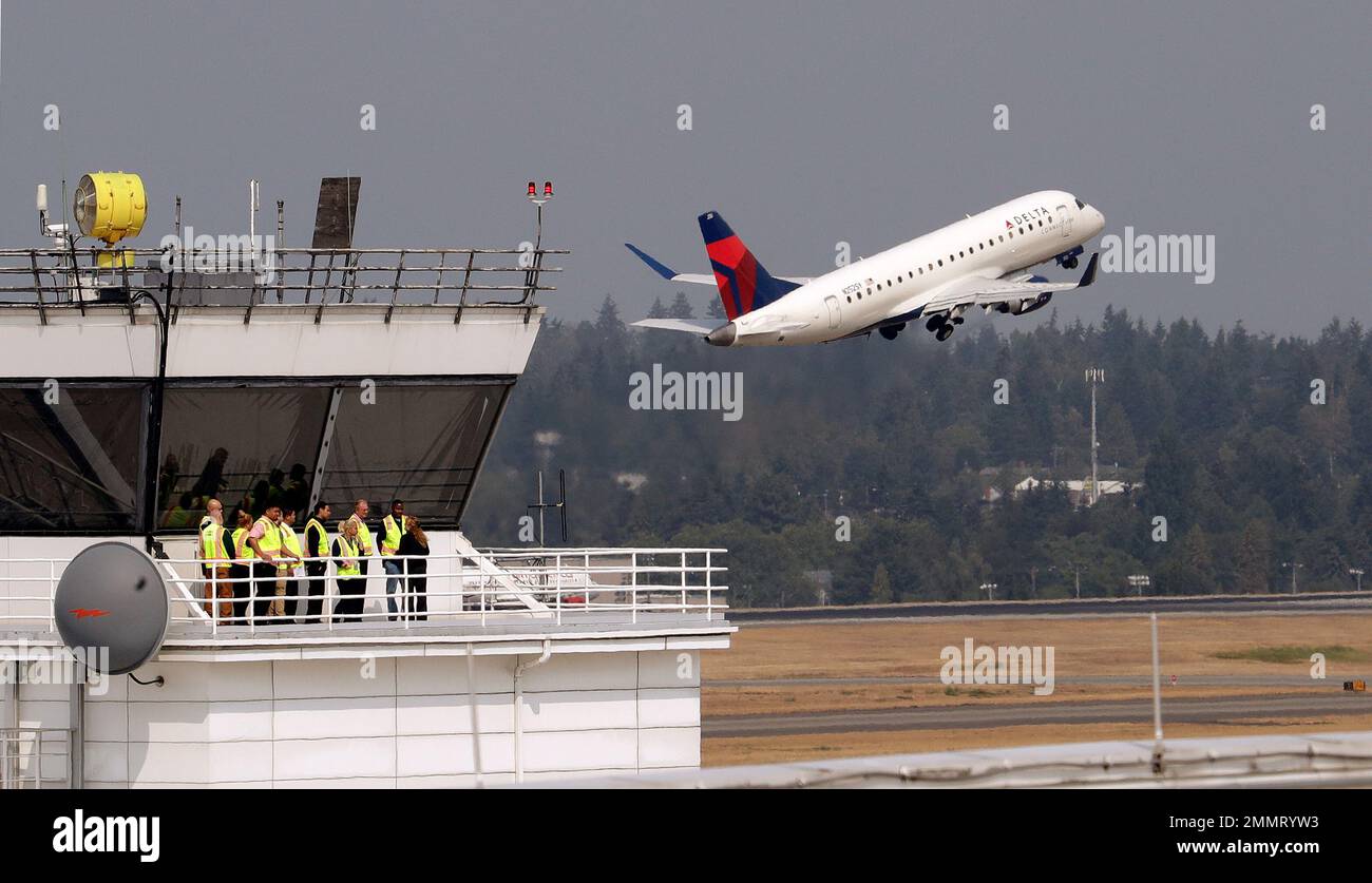 People stand at the ramp tower, used to control airplane traffic, as a ...
