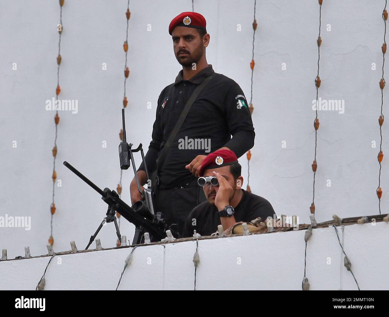 Police commandos monitor the area from the rooftop of the parliament ...