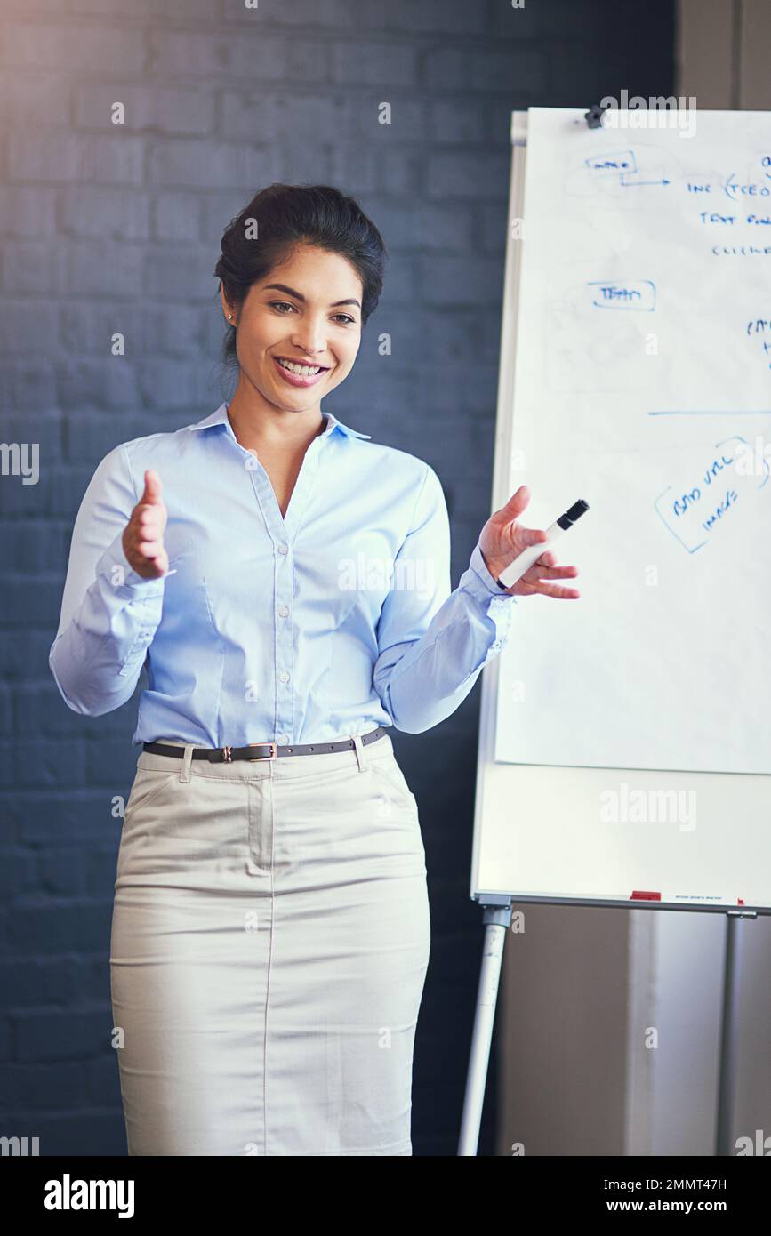 Presenting her ideas with confidence. a young businesswoman giving a presentation during a ...