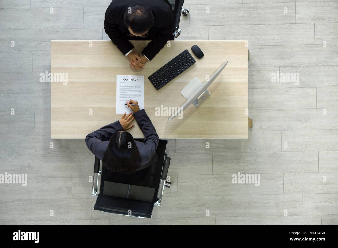 Young candidate in gray suit put a sign on the contract document after ...