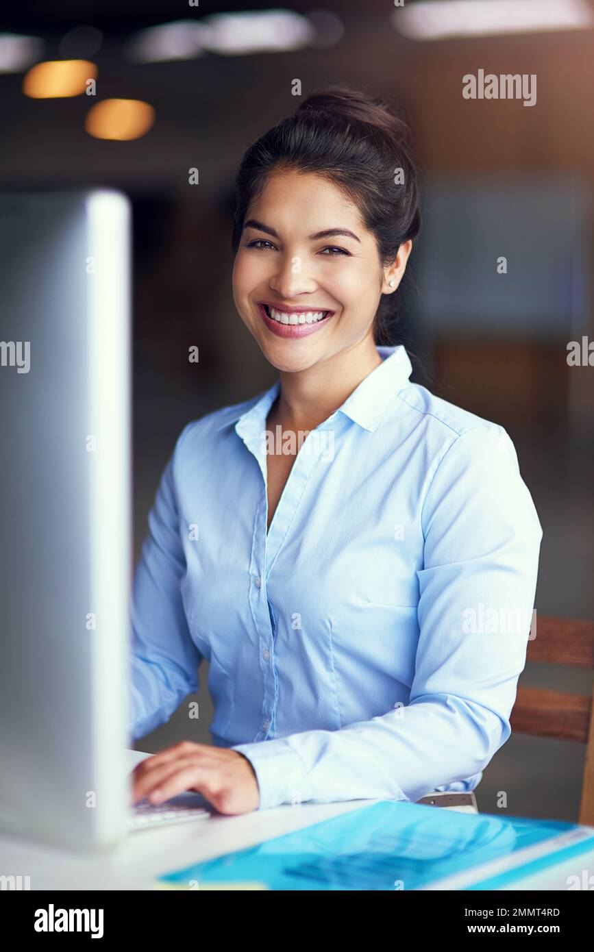 Getting her work done with a smile. Portrait of a young businesswoman ...