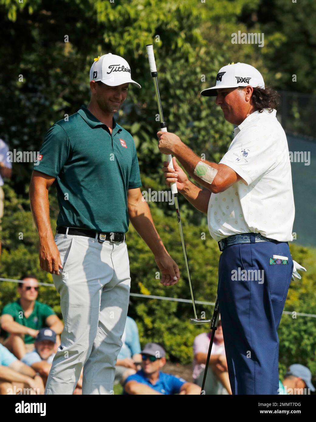 Adam Scott, left, of Australia, and Pat Perez look at the putter that ...