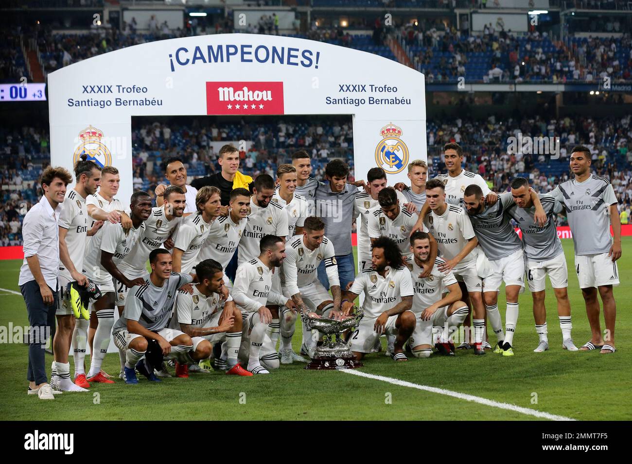 Real Madrid players pose with the trophy after winning the Santiago ...