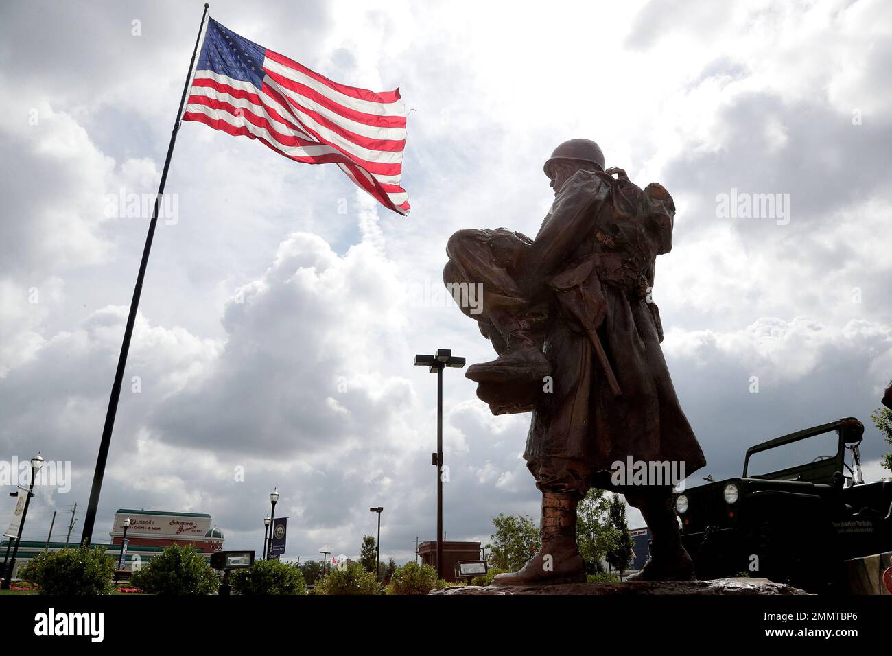 A bronze statue of a soldier carrying a wounded soldier is seen near a ...