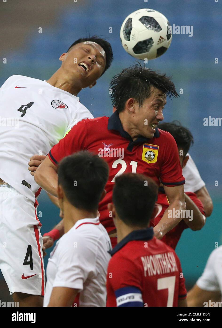 Hong Kong's Lau Hok Ming, left, fights for the ball with Laos' Tiny ...